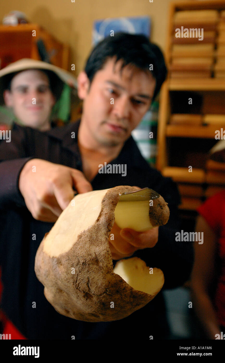 A sushi chef shows his skills with a knife as he cuts the skin off ...