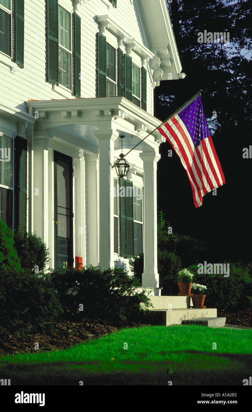 American flag hangs from the front porch of a traditional colonial home ...