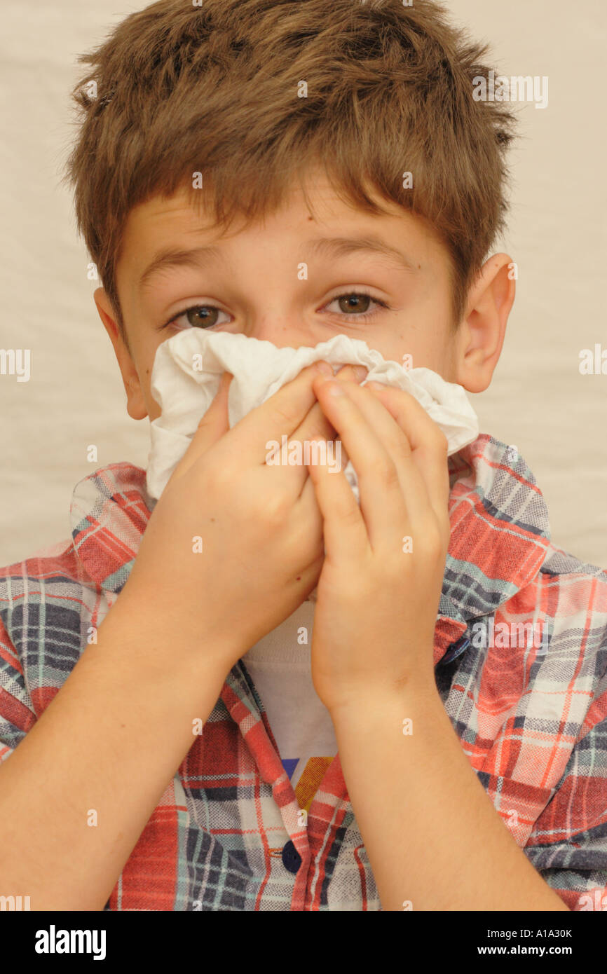 Young boy blowing nose with paper tissue wearing pyjamas Stock Photo ...