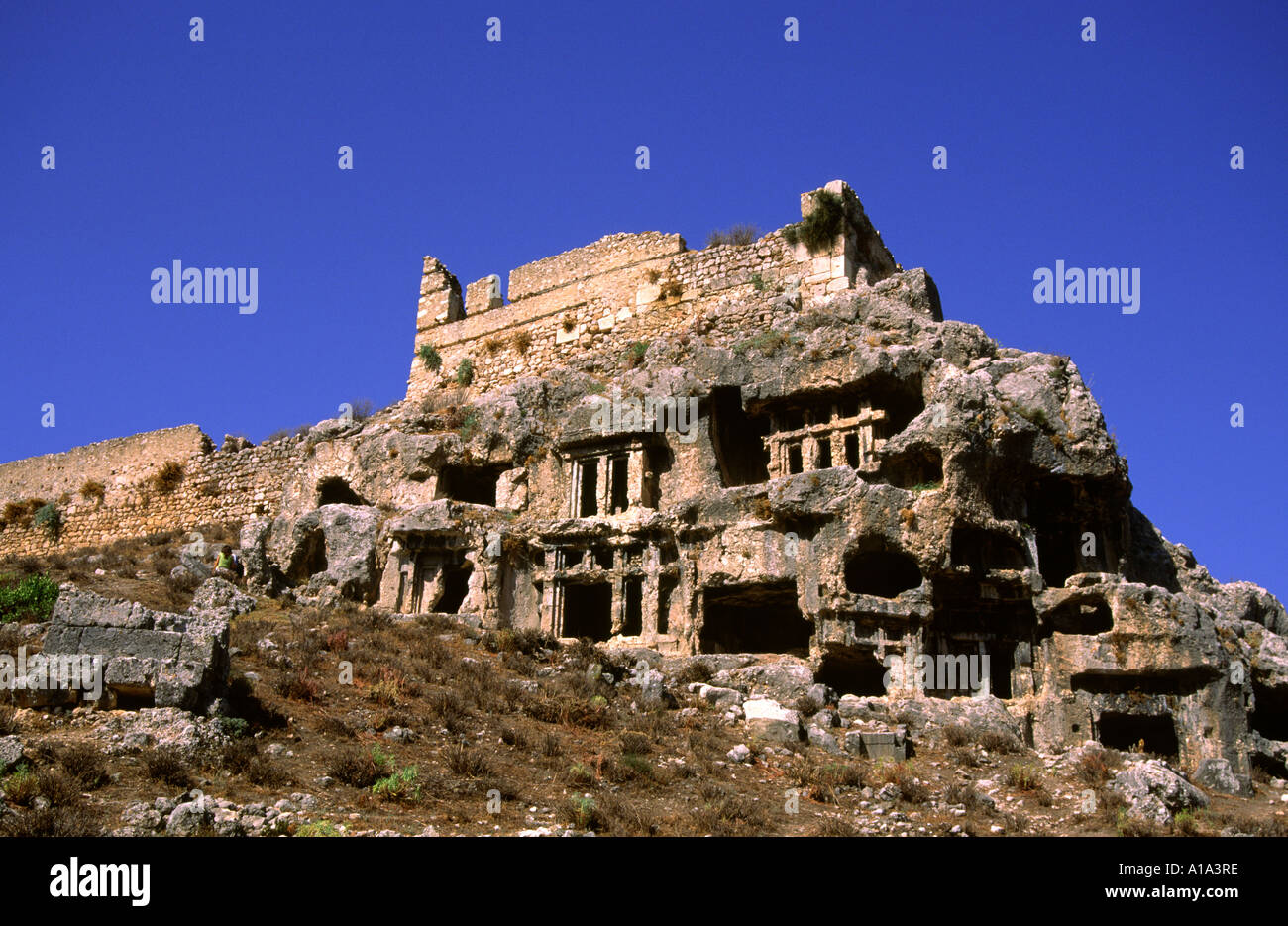 Carved Lycian tombs at the ancient city of Tlos with the castle of ...