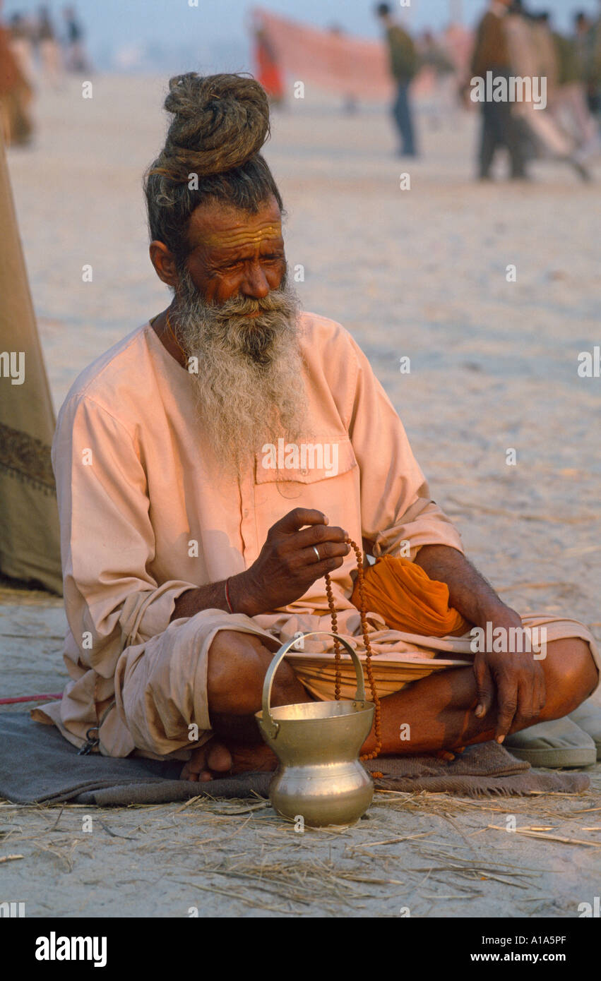 Pilgrim praying with prayer beads on the banks of the Sangam, Maha ...