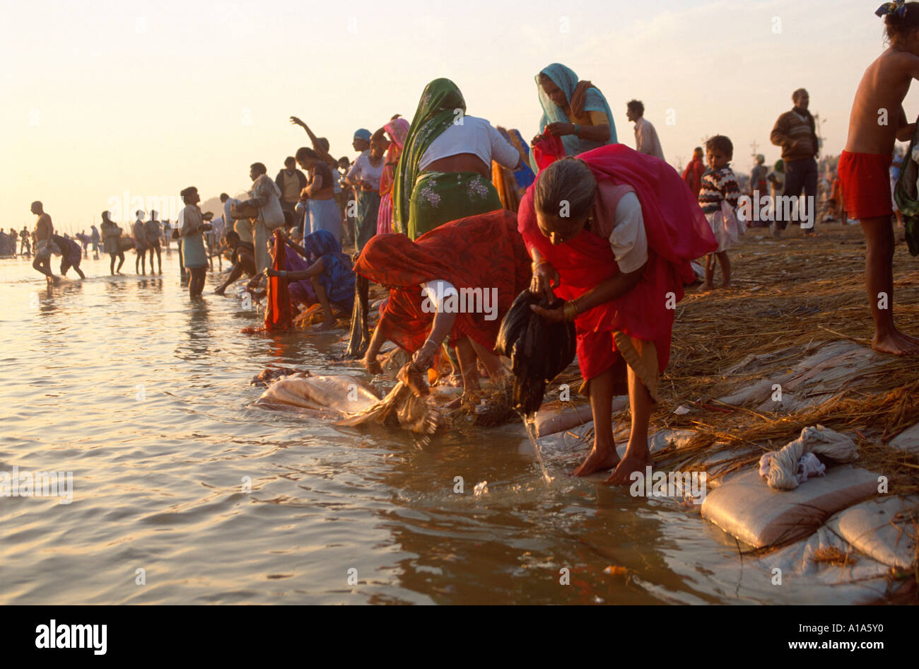 Pilgrims washing clothes on the banks of the Sangam at sunset, Maha ...