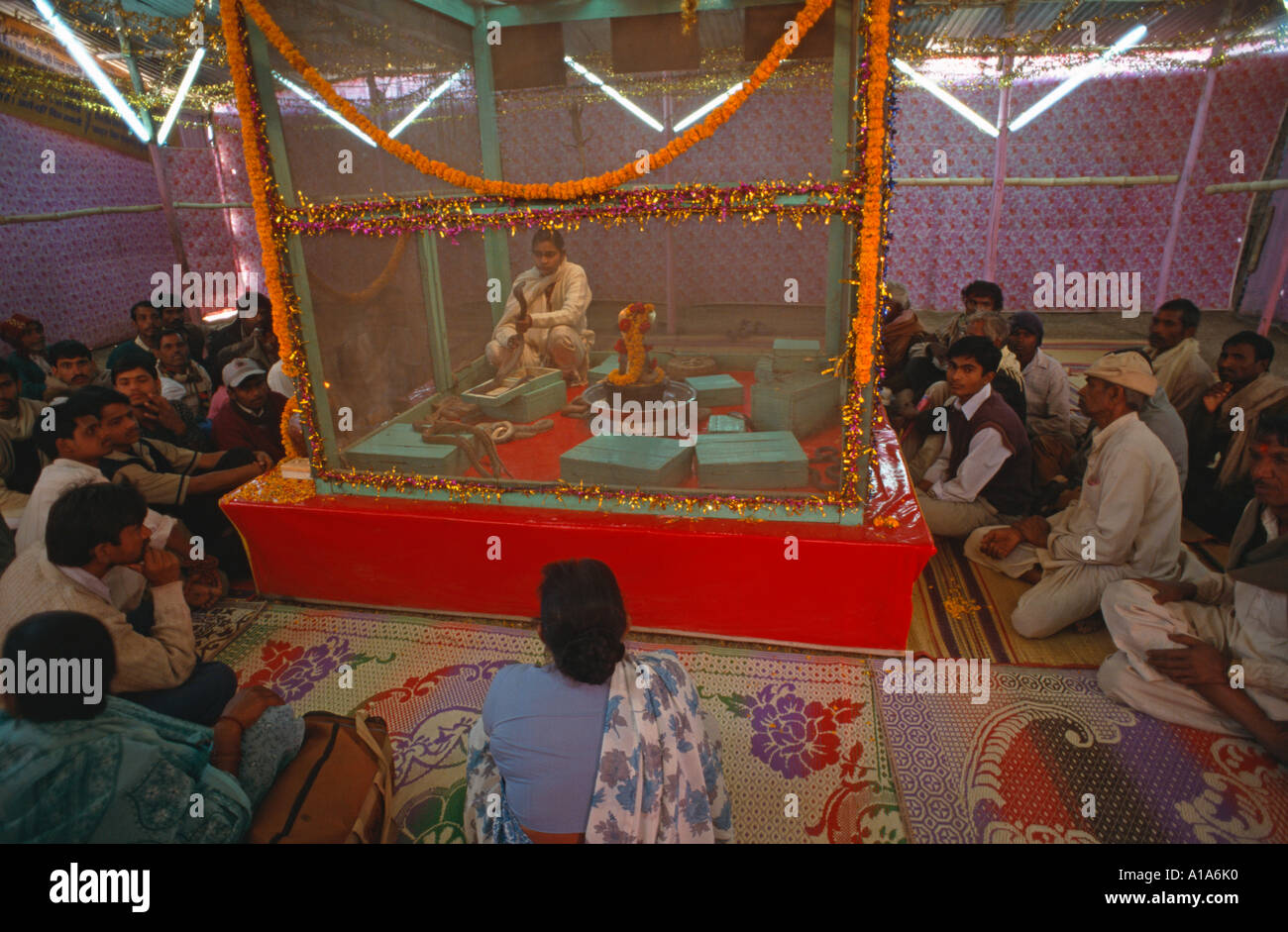 Spectators watching a woman in a cage of snakes at a freak show at the ...