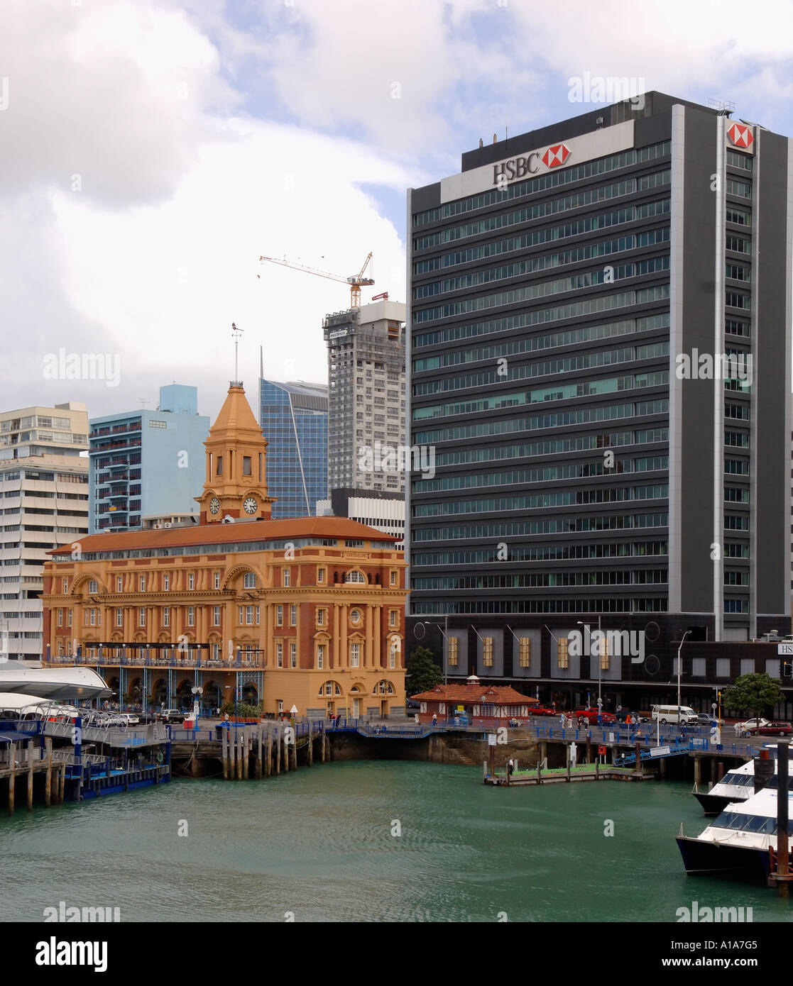 The sandstone and brick Auckland Ferry building and HSBC office tower ...
