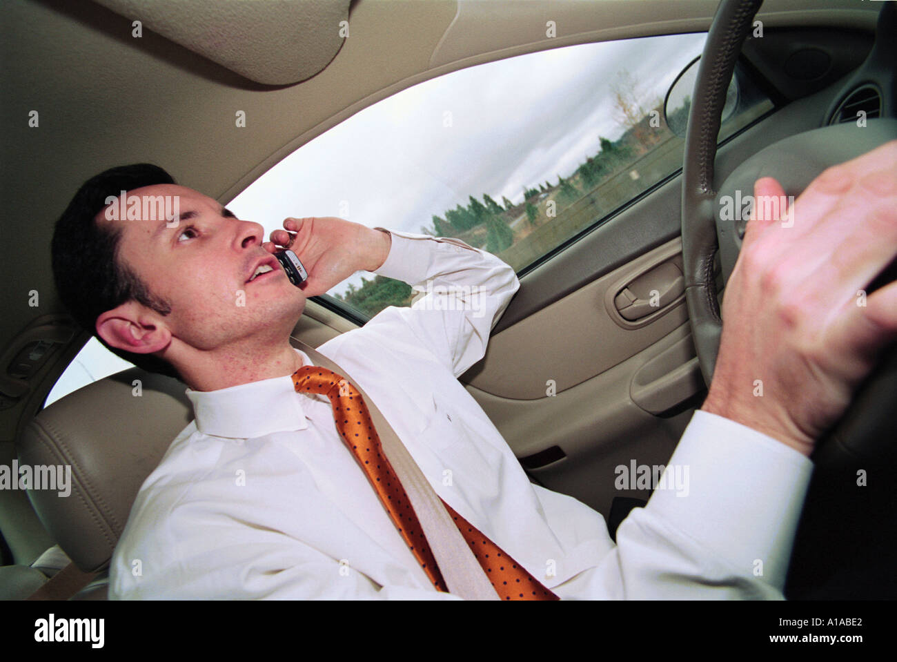 A salesman driving his car while talking on his cell phone Stock Photo ...