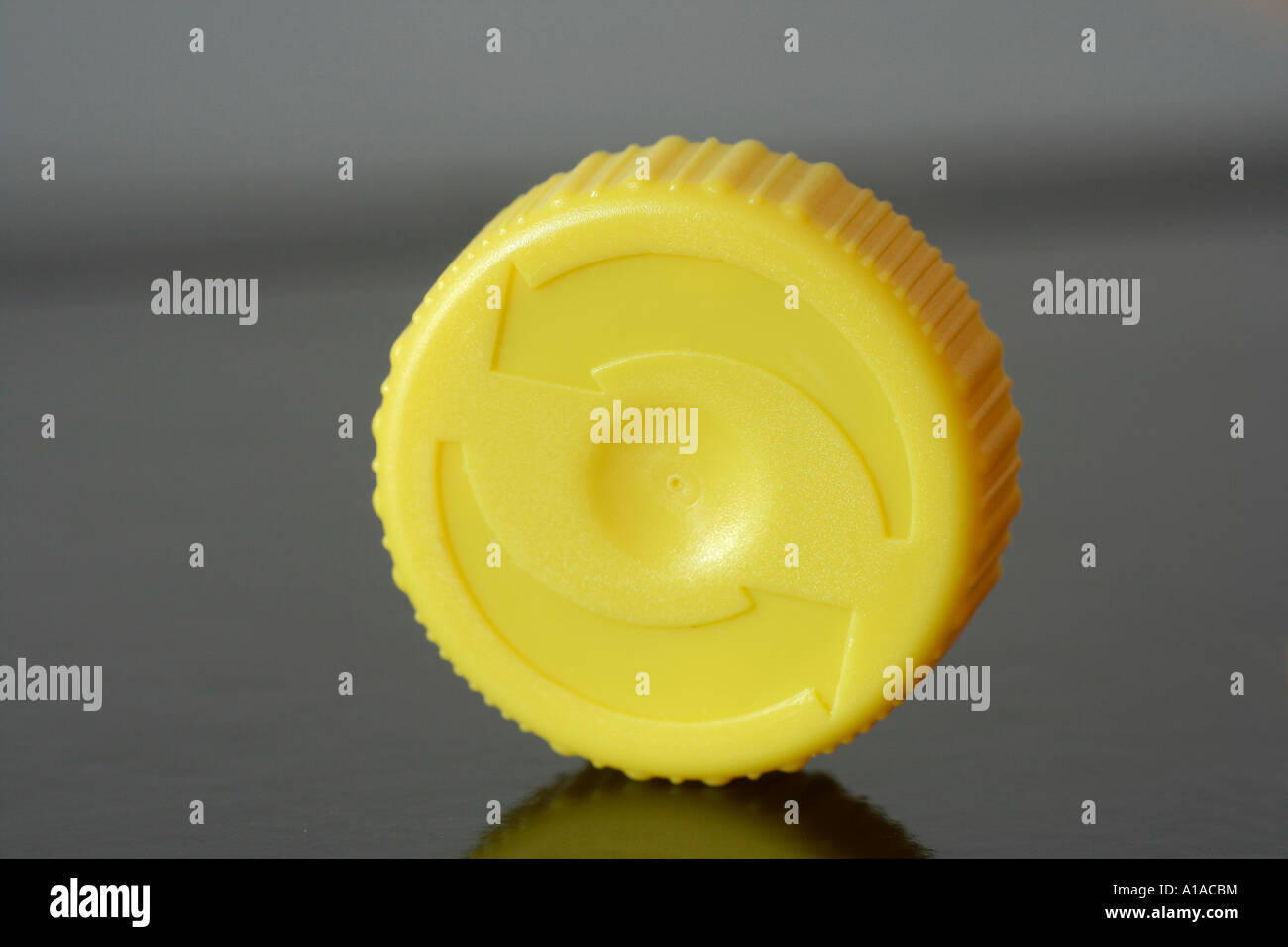 Yellow screw cap with recycling symbol Stock Photo - Alamy