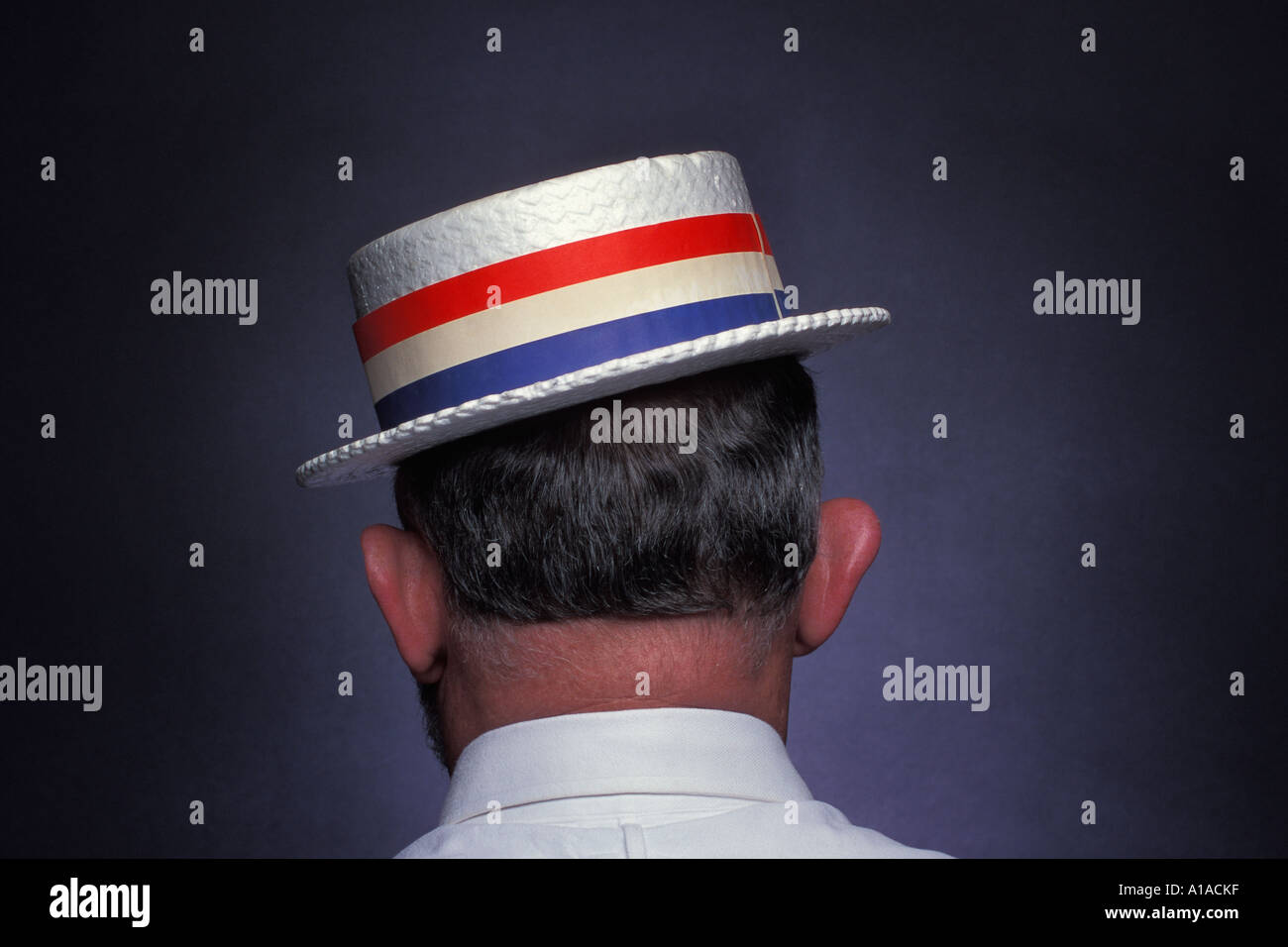 Back of head view of man wearing white simulated straw hat with red ...