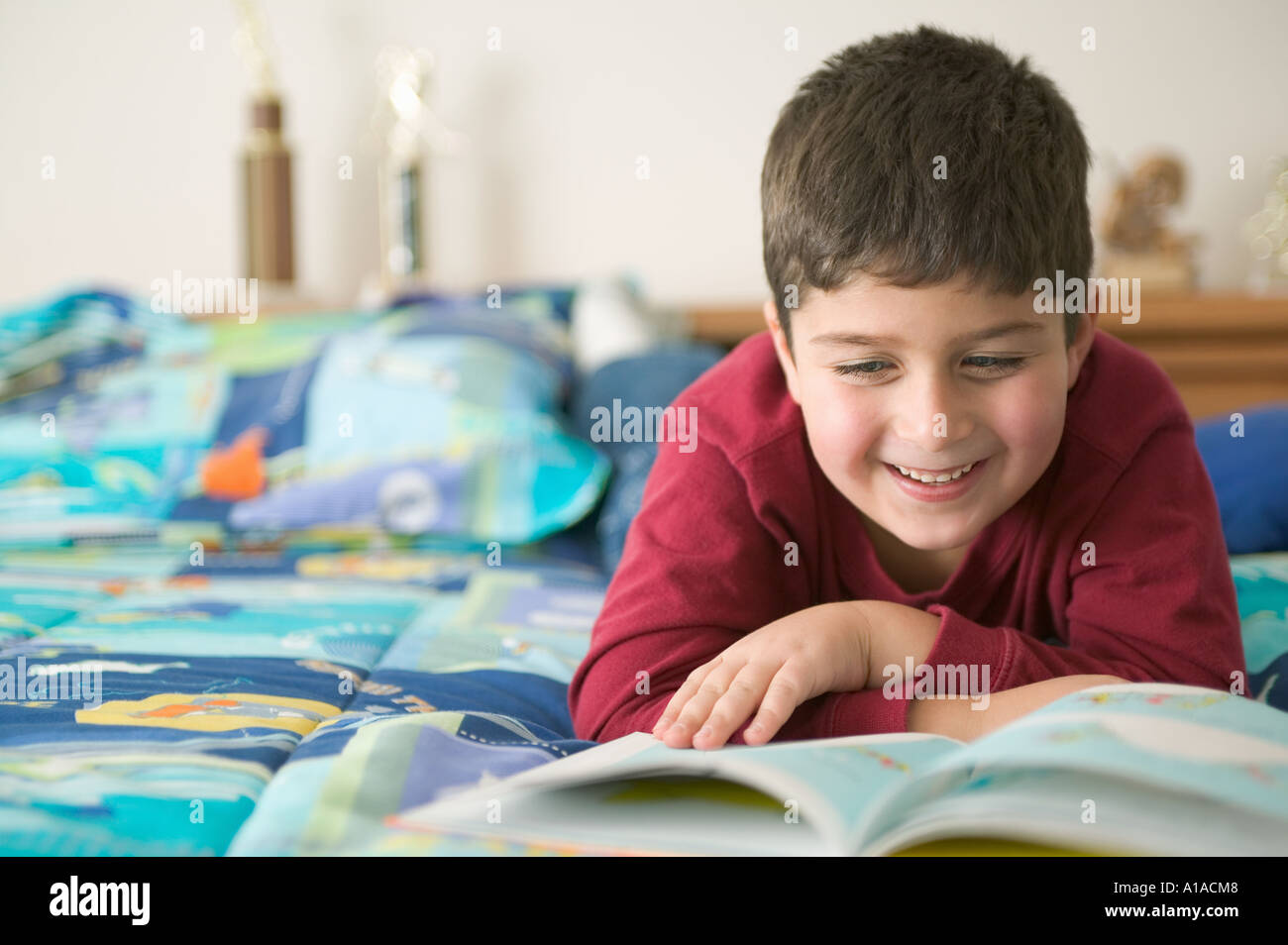 Boy reading a book and smiling Stock Photo - Alamy