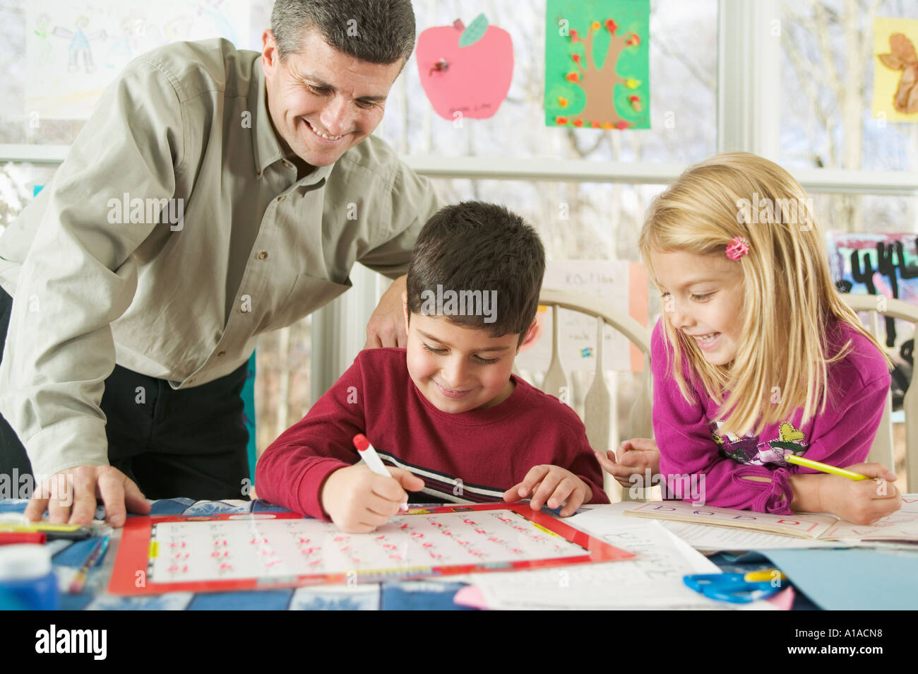 Father helping children with homework Stock Photo - Alamy
