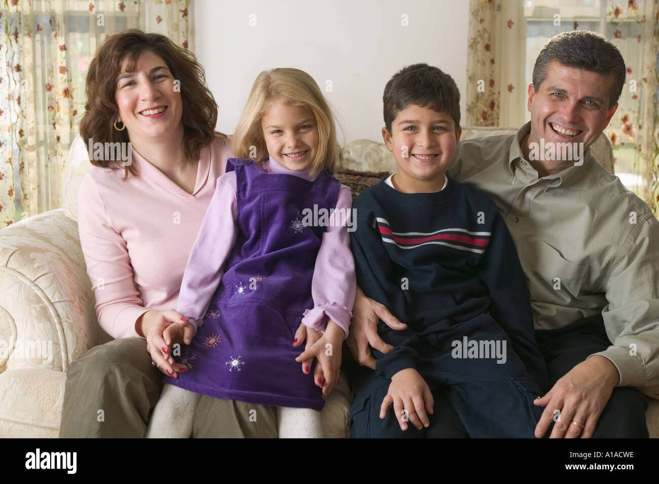 Relaxed smiling family four hi-res stock photography and images - Alamy