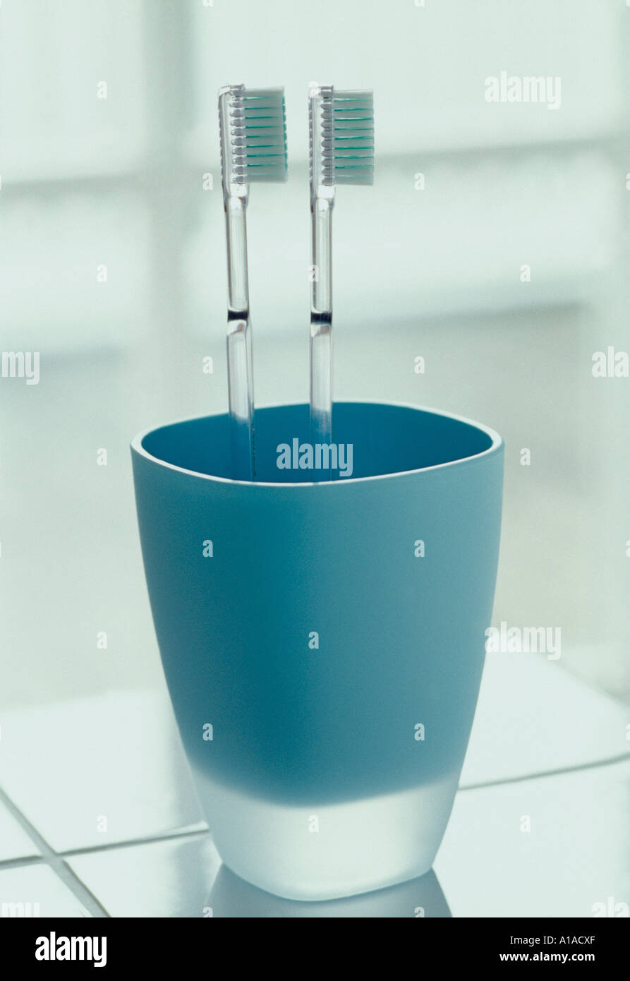 Two toothbrushes in a cup Stock Photo - Alamy