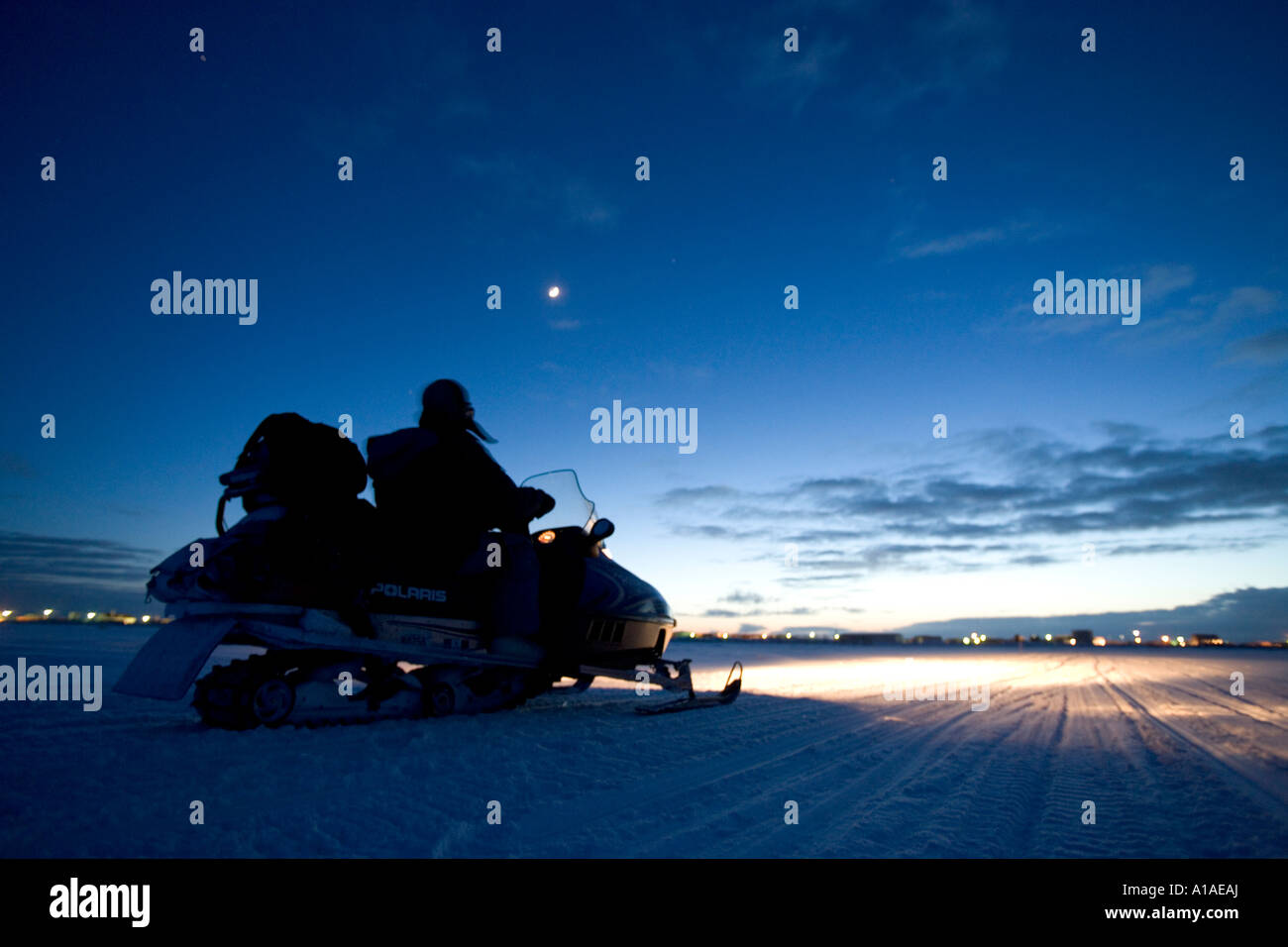 Usa Alaska Unalakleet Man Rides Snowmobile On Sea Ice Under Crescent