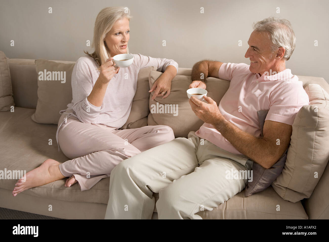 Couple on sofa drinking tea Stock Photo - Alamy