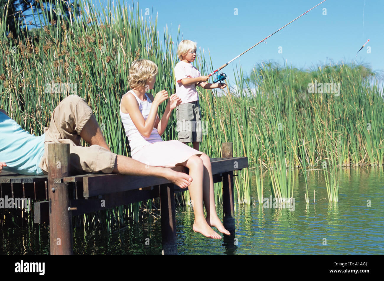 Boy fishing with parents Stock Photo - Alamy