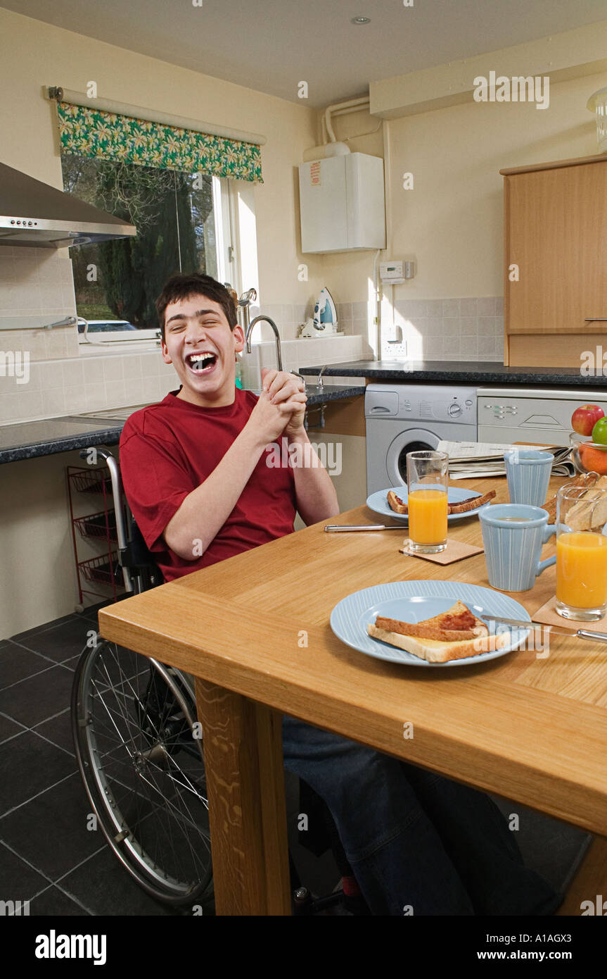Disabled man laughing at breakfast table Stock Photo - Alamy