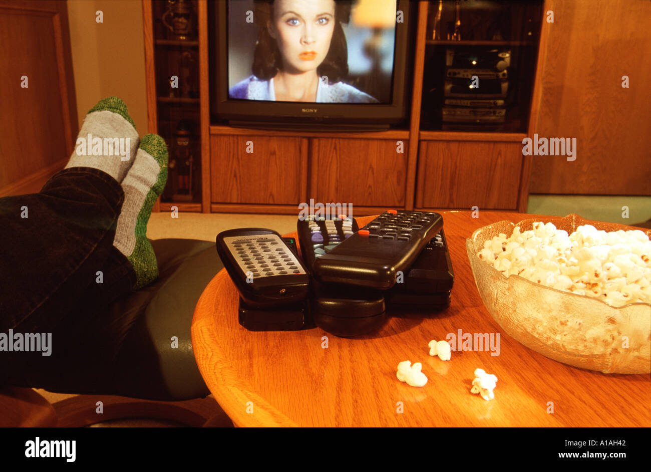 Feet up watching television with popcorn and remote Stock Photo - Alamy