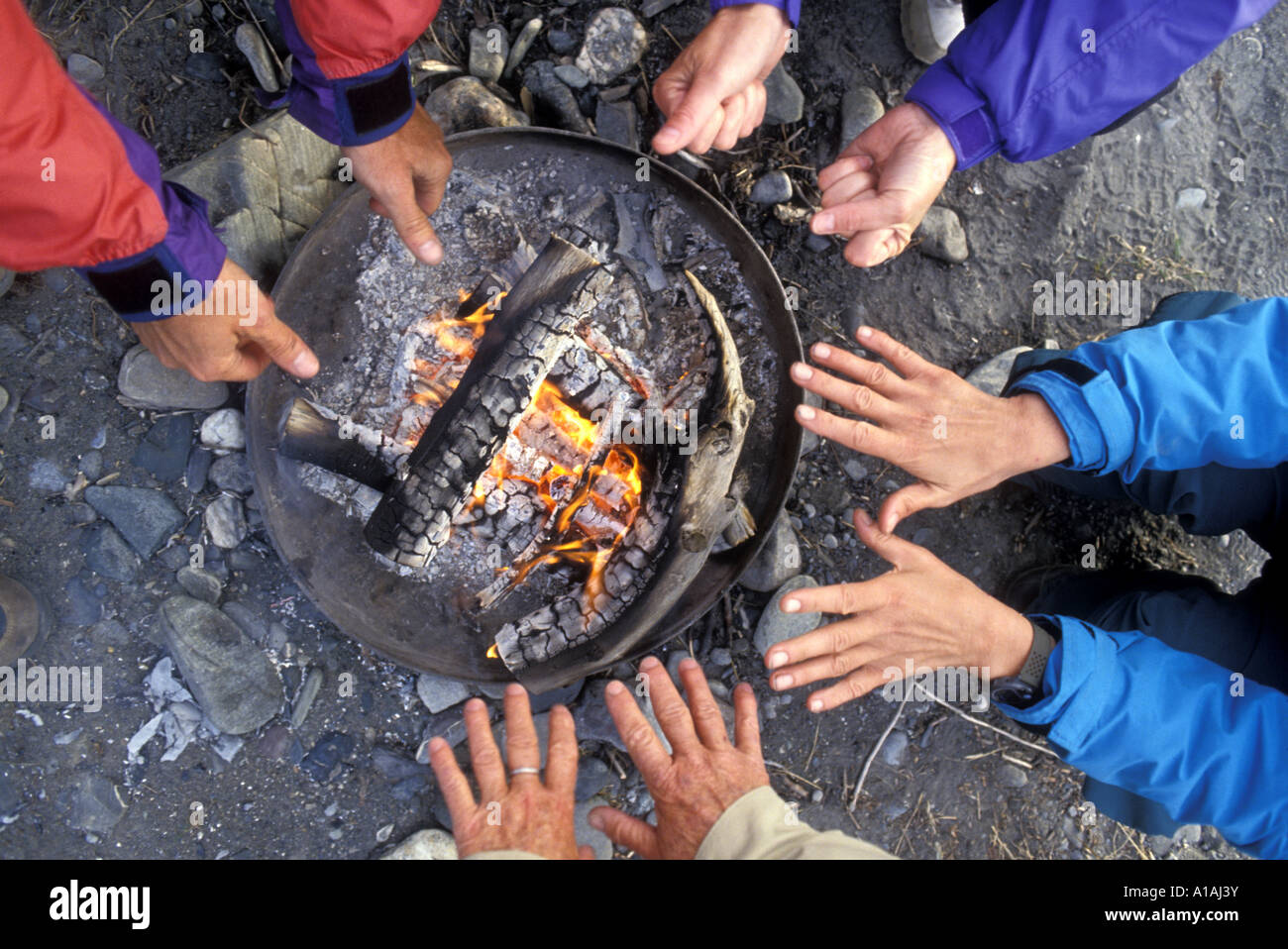 USA Alaska Arctic National Wildlife Refuge Campers warm hands around ...