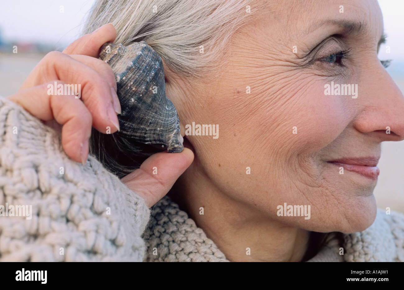 Woman shell listening hi-res stock photography and images - Alamy