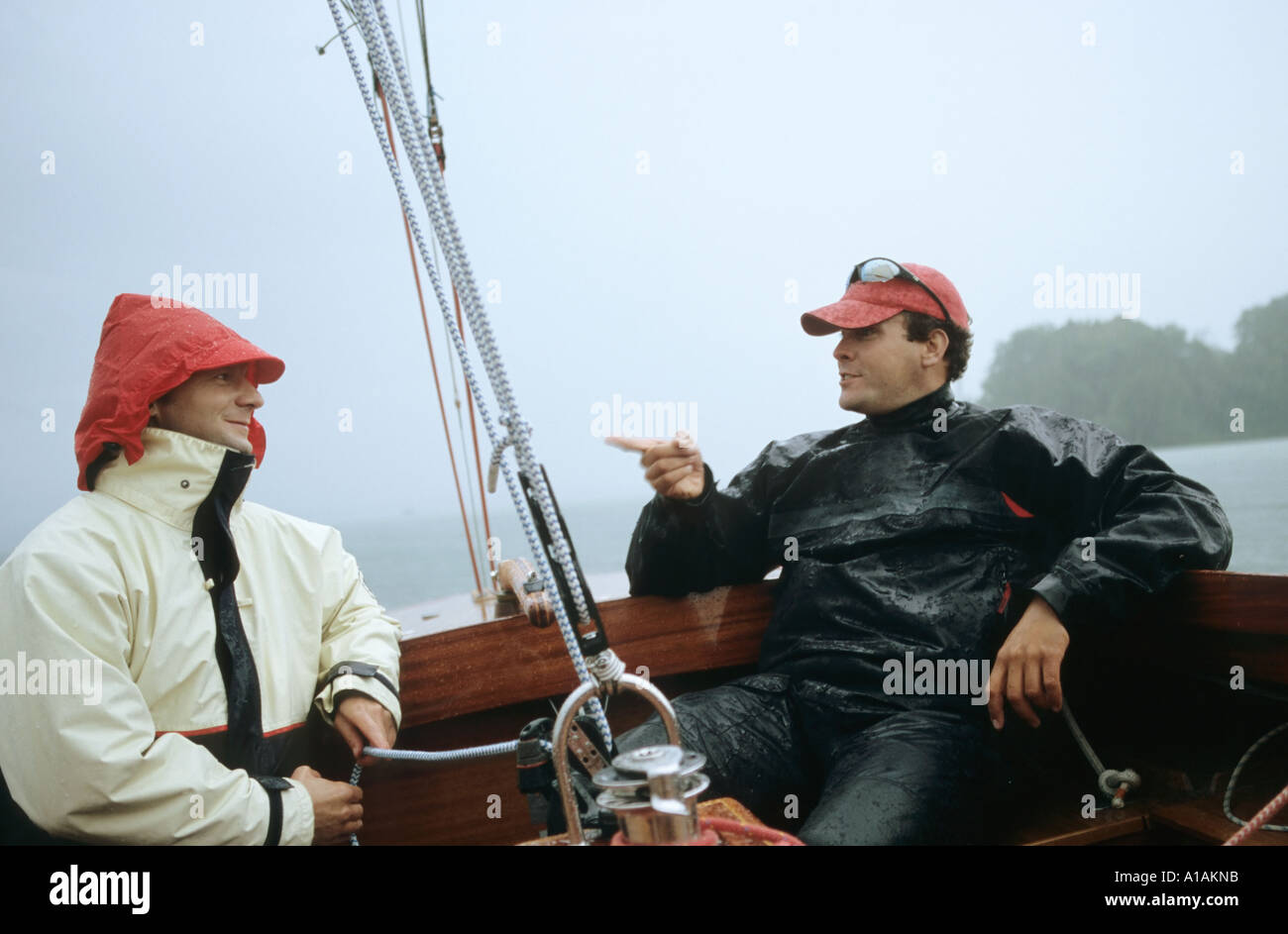 Two men sitting and talking on a boat Stock Photo - Alamy