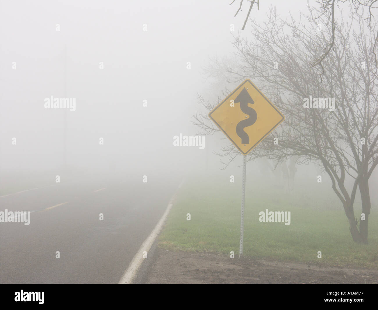 Curved road sign in fog Stock Photo - Alamy