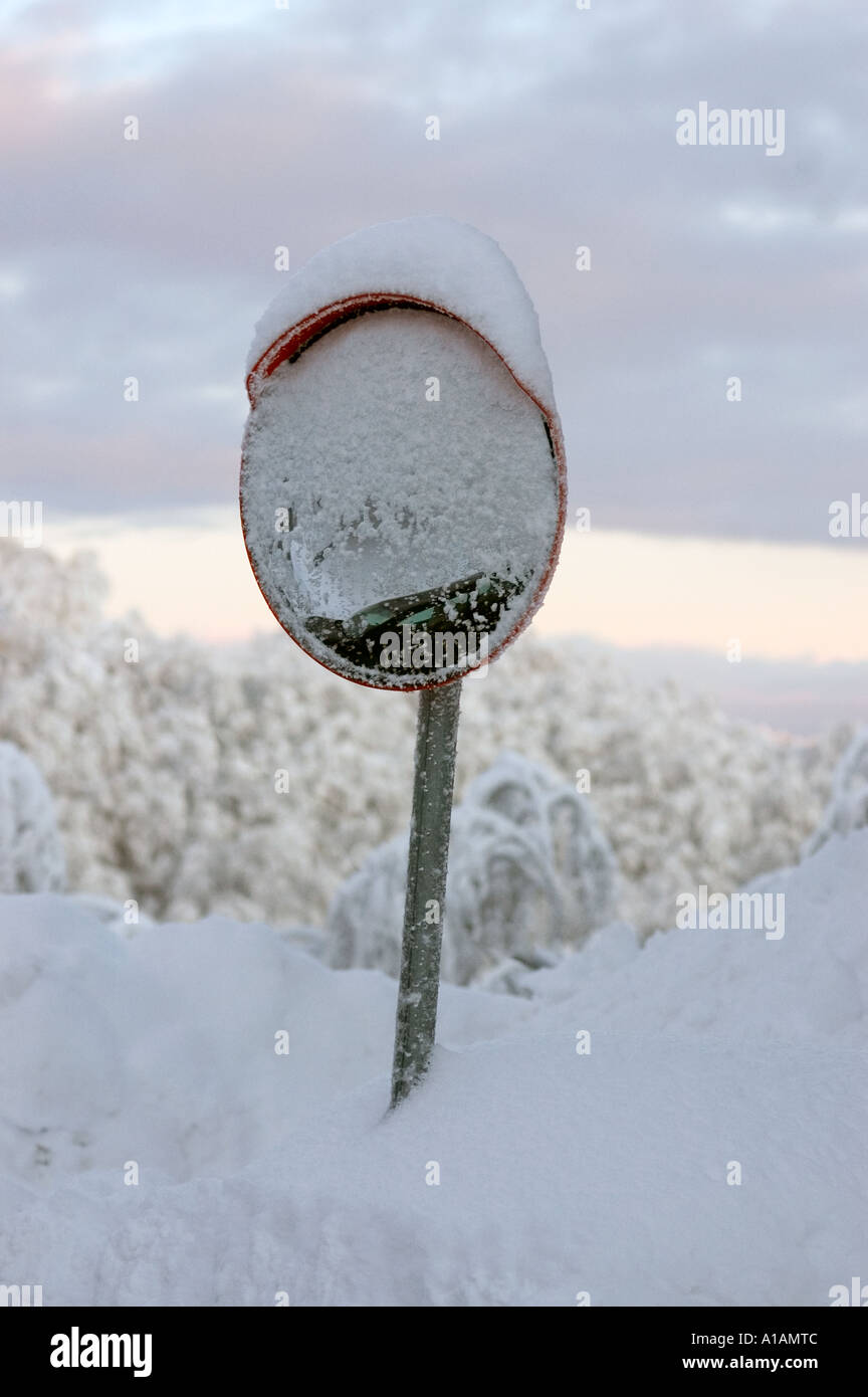 road safety circular mirror covered with snow and cloudy sky Stock ...