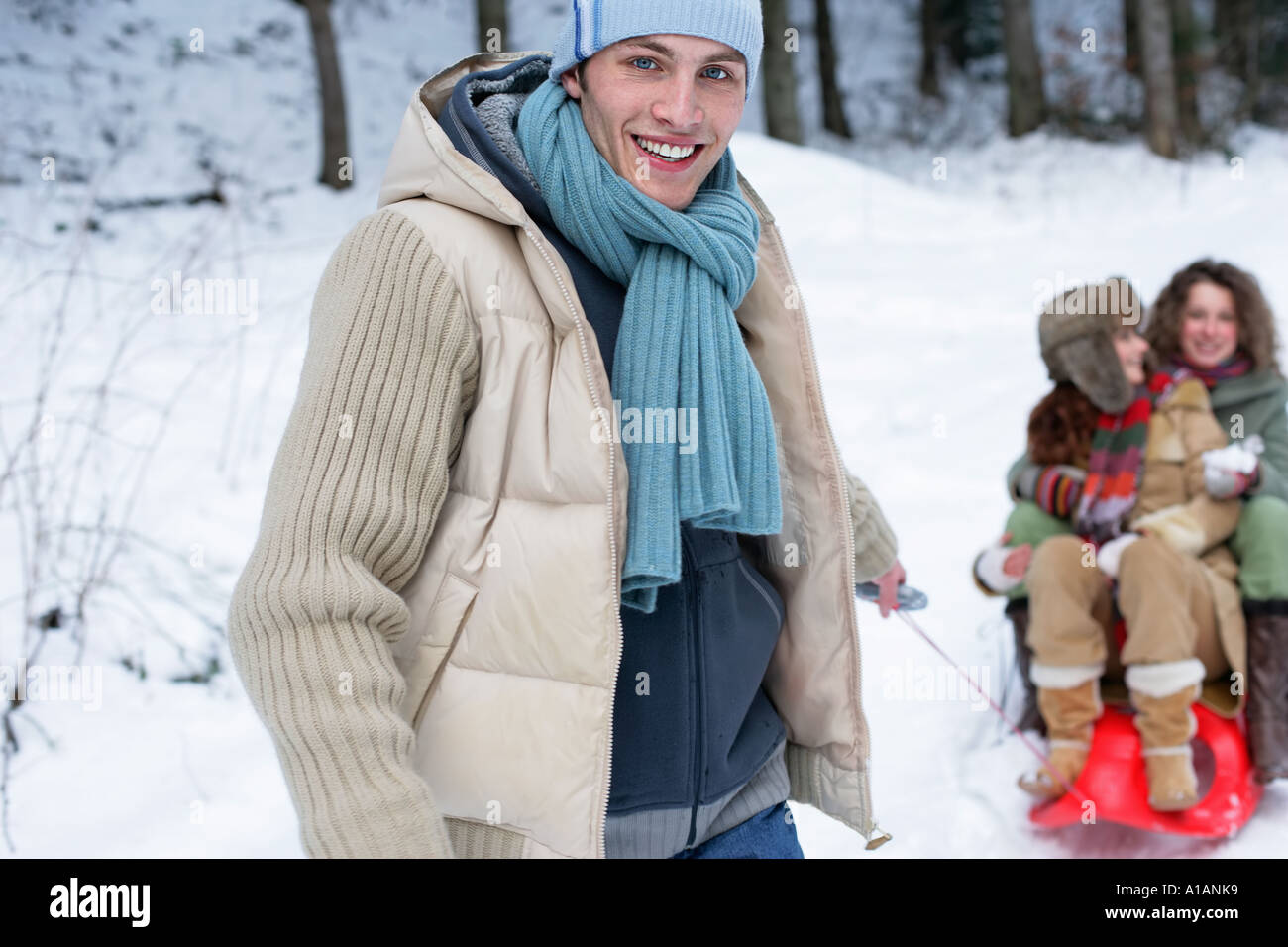 Man pulling women on a sled Stock Photo - Alamy
