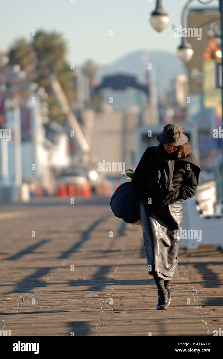 Homeless woman carrying all her belongings in bags walking along the ...