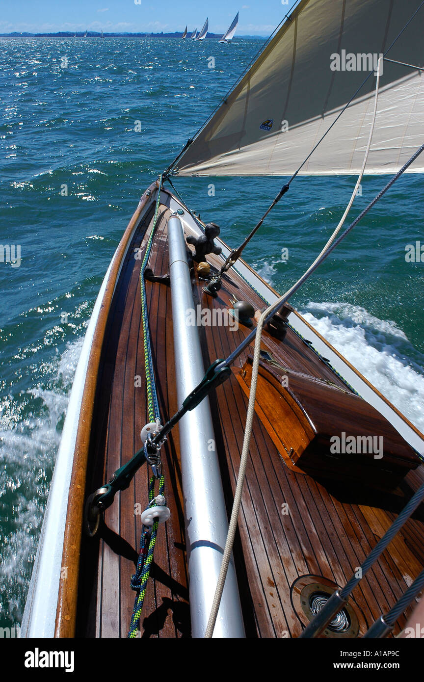 Bow of a classic racing yacht powering through a calm sea in pursuit of ...