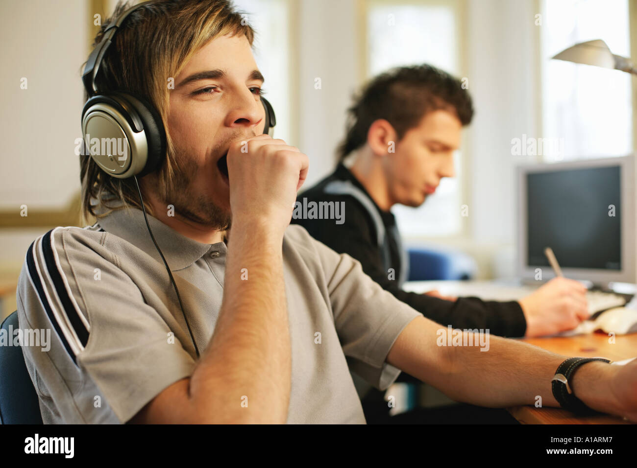 Man in headphones yawning Stock Photo - Alamy
