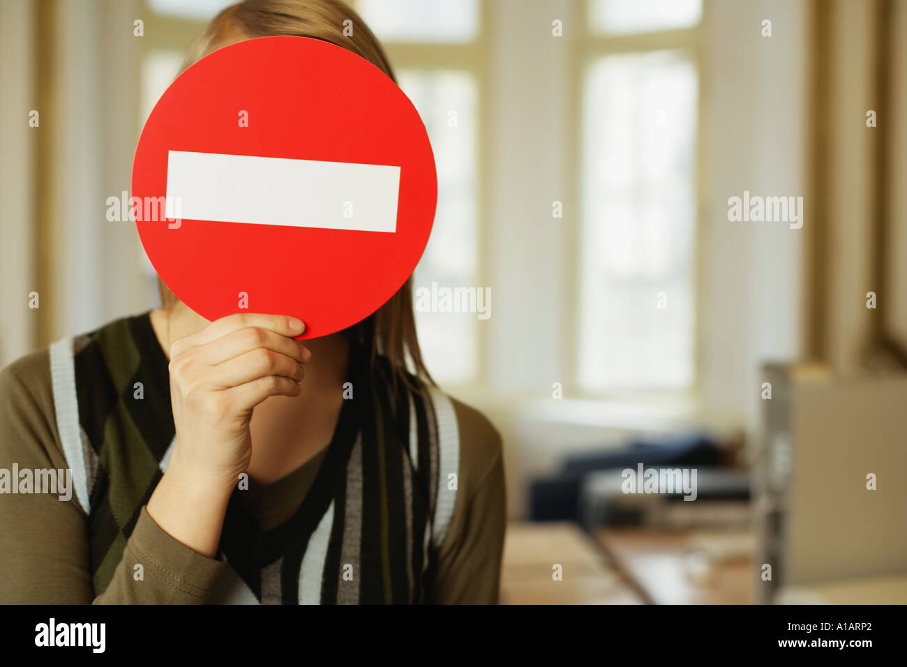 Woman covering her face with a no entry sign Stock Photo - Alamy