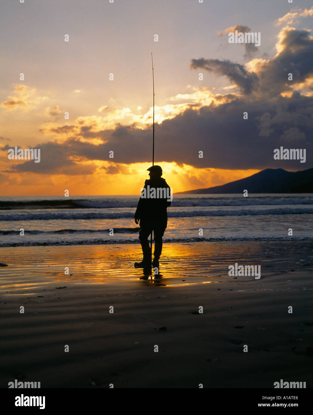 sea angler standing on a beach on irelands atlantic west coast at ...