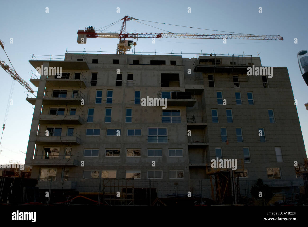 looking up the side of a semi contructed block of flats overshadowed by ...