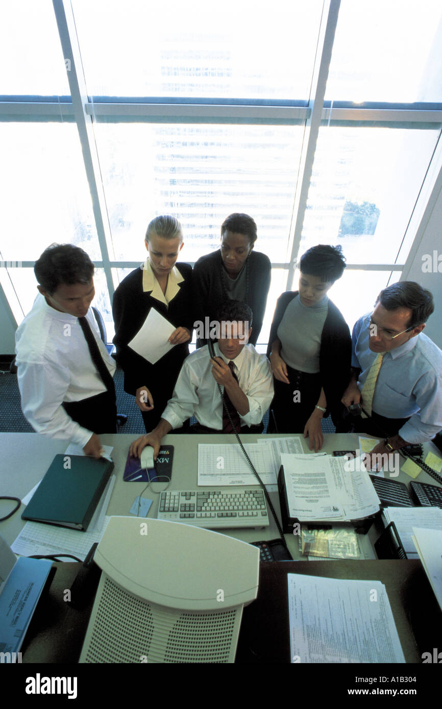 BIRDSEYE VIEW OF GROUP OF WORKERS STANDING AROUND COLLEAGUE Stock Photo ...