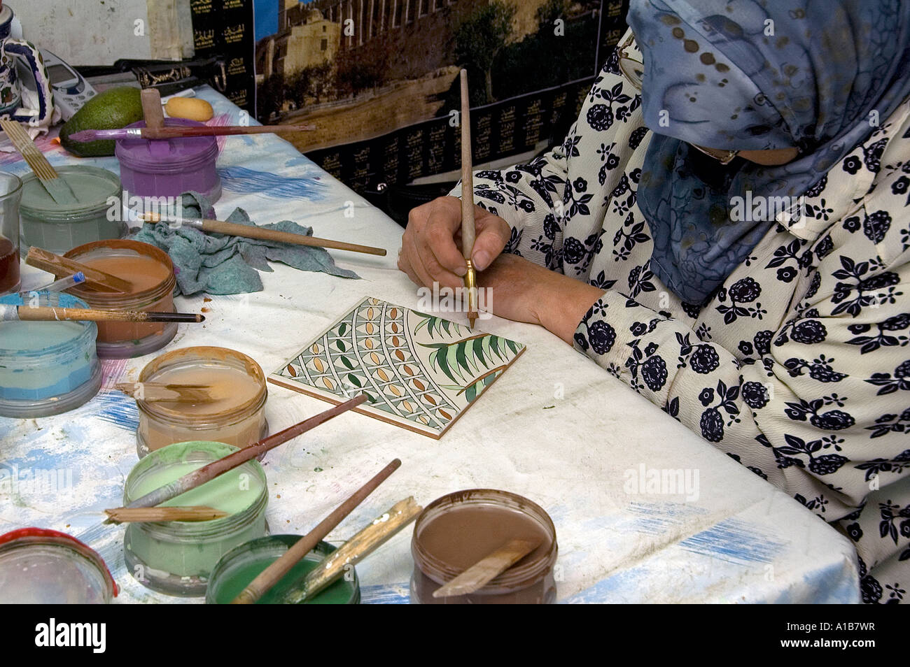 A Palestinian woman paints a ceramic tile in an Armenian tile workshop ...
