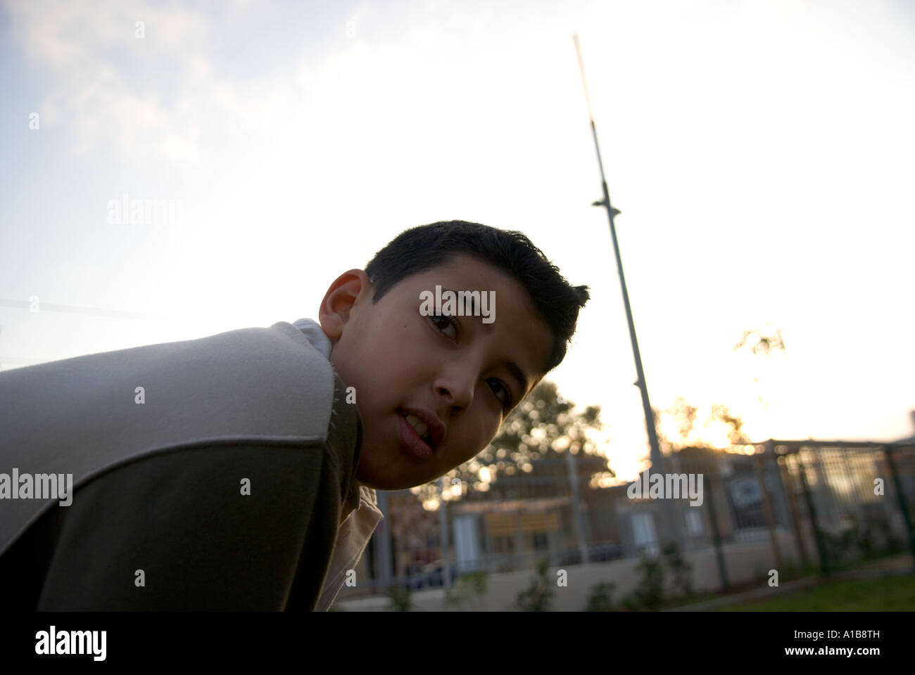 a low angle shot of a young boy looking back over his shoulder in a ...