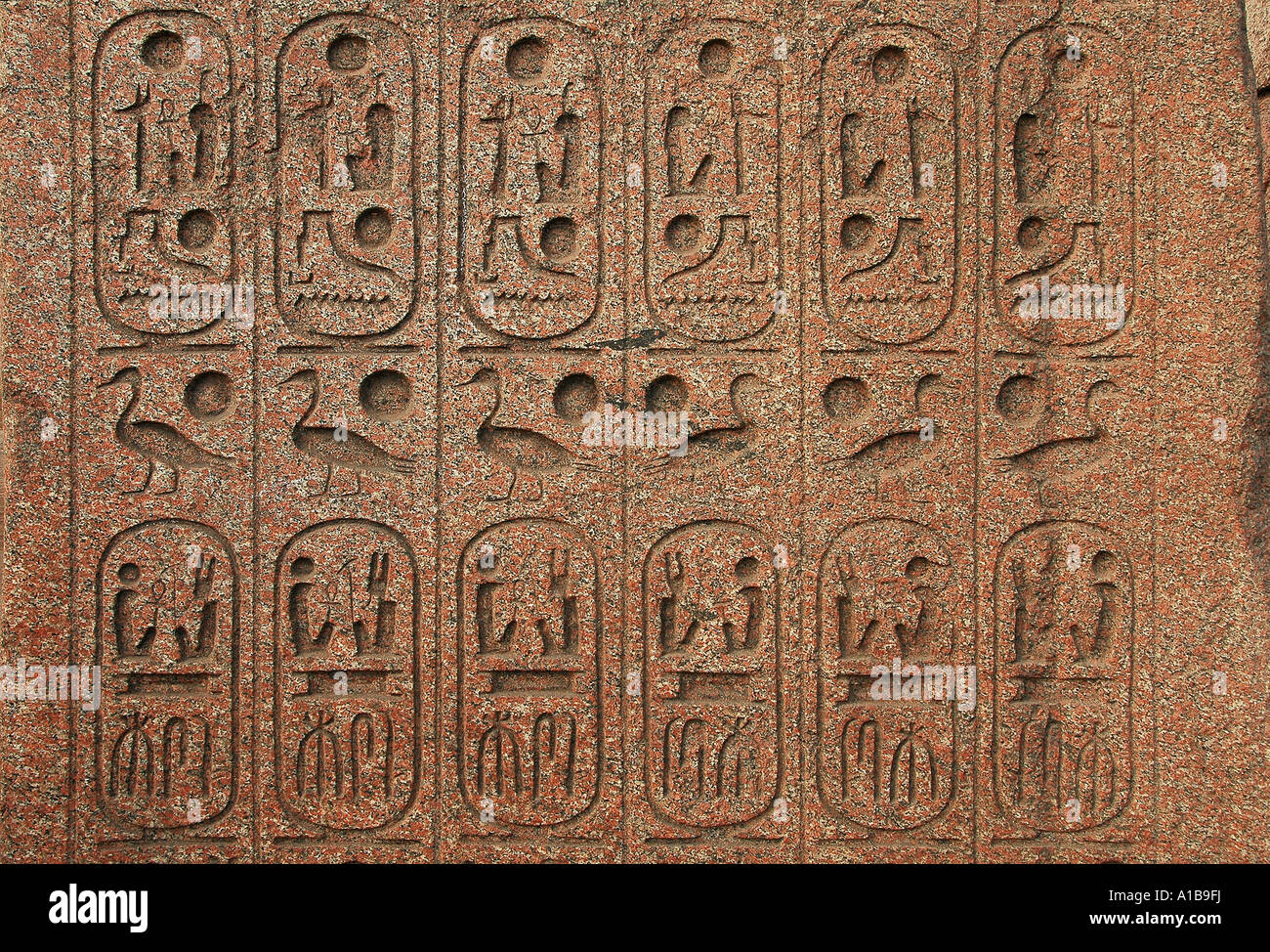 Hieroglyphic script engraved into a granite wall in Egypt Stock Photo ...