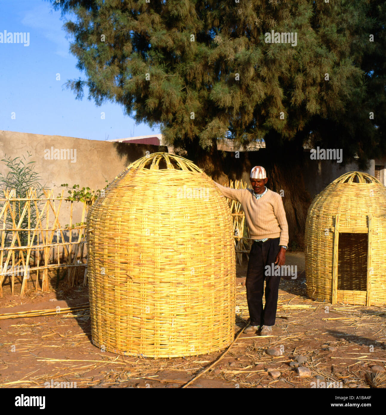 Portrait of man beside woven bamboo shower cubicle Morocco Africa T ...