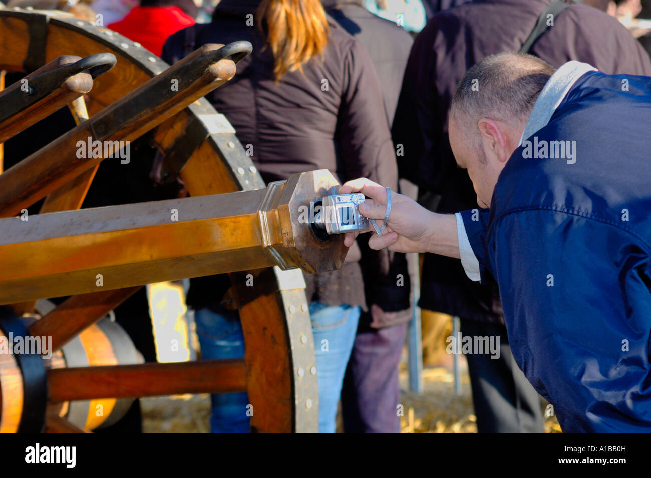 A man photographing down the barrel of an old muzzle-loading cannon ...