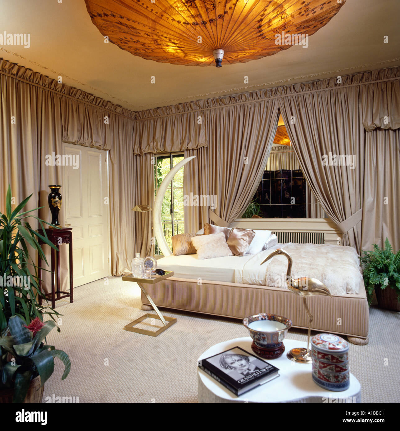 Grey fabric-draped walls and coronet bedhead. Bird statues on grey ...