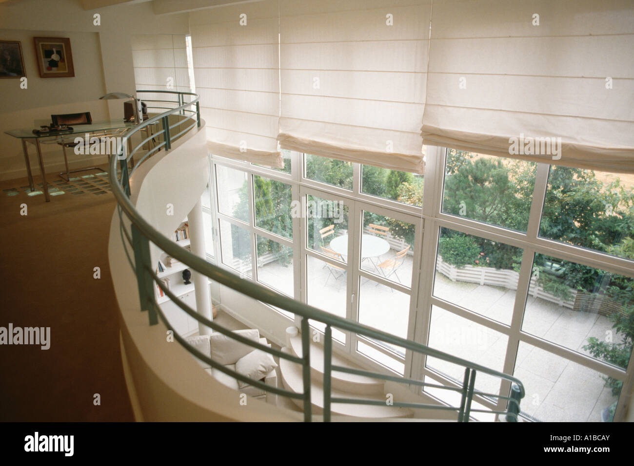View of garden from internal balcony, cream blinds at floor-to-ceiling ...