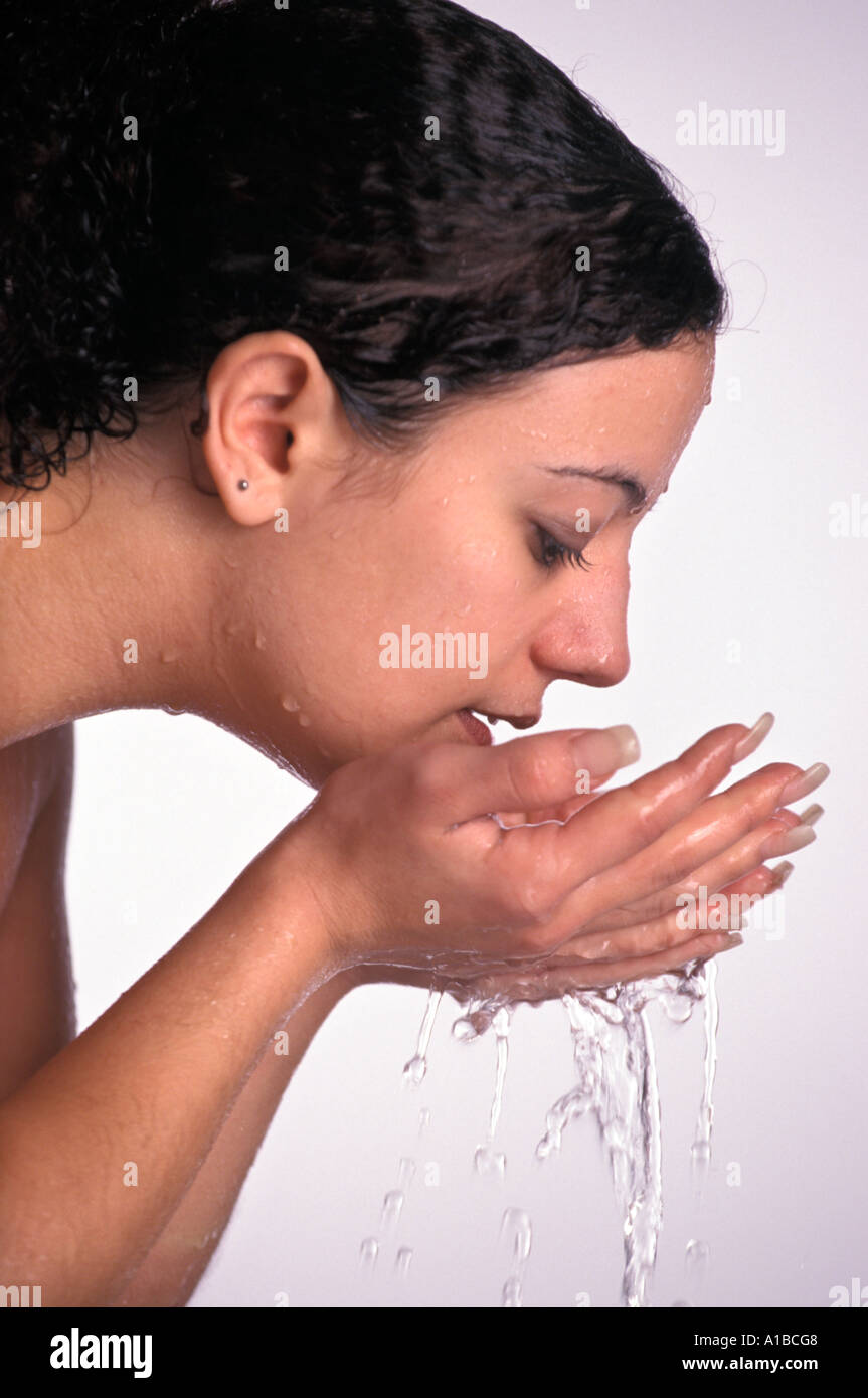 Latino woman washing face Stock Photo - Alamy