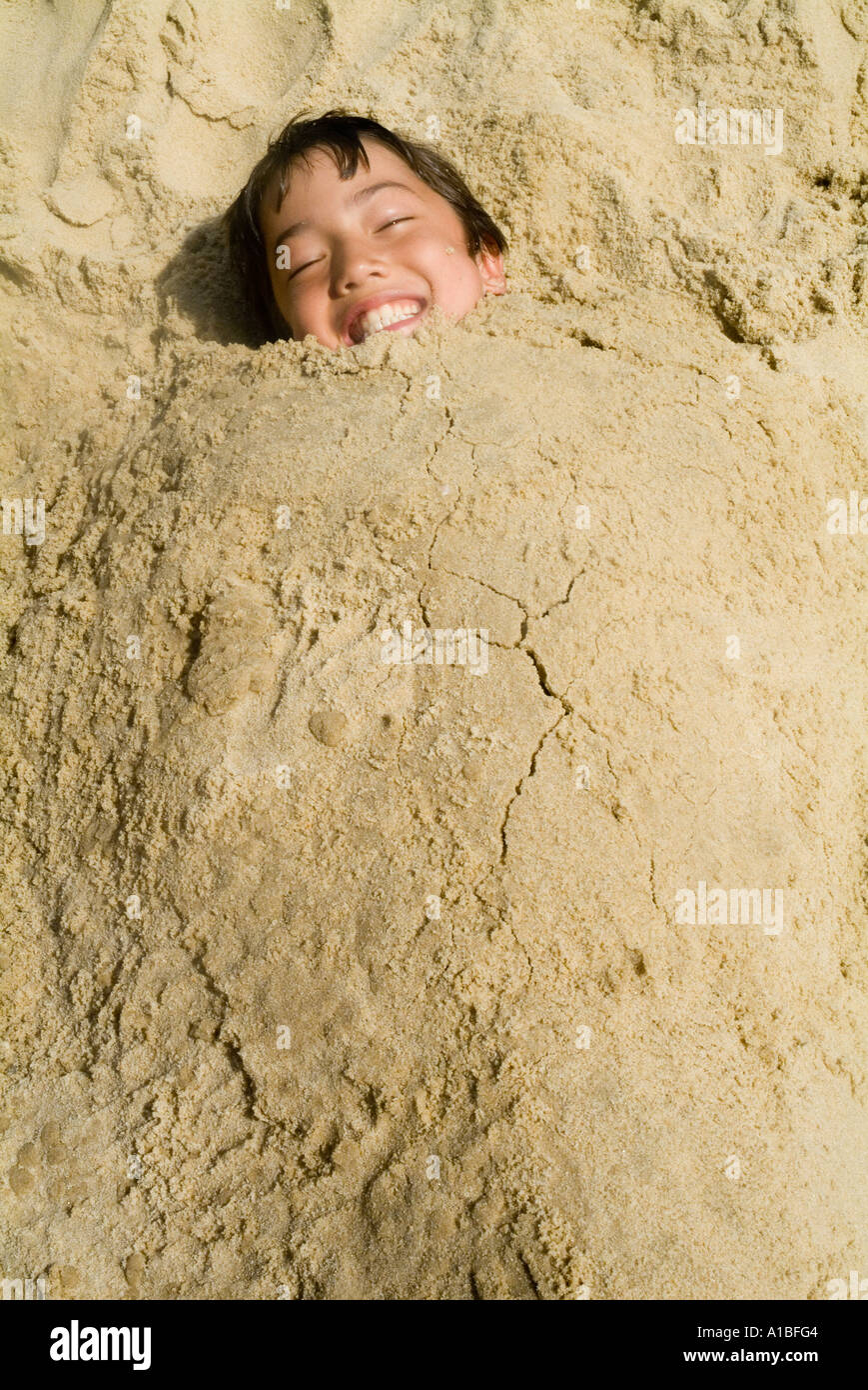 Boy buried in the sand at the beach Stock Photo - Alamy