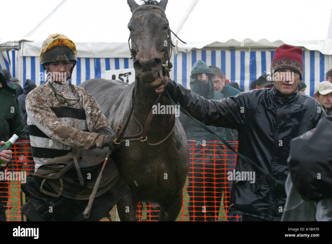mud splattered jockey and horse with owner in parade ring maralin point ...