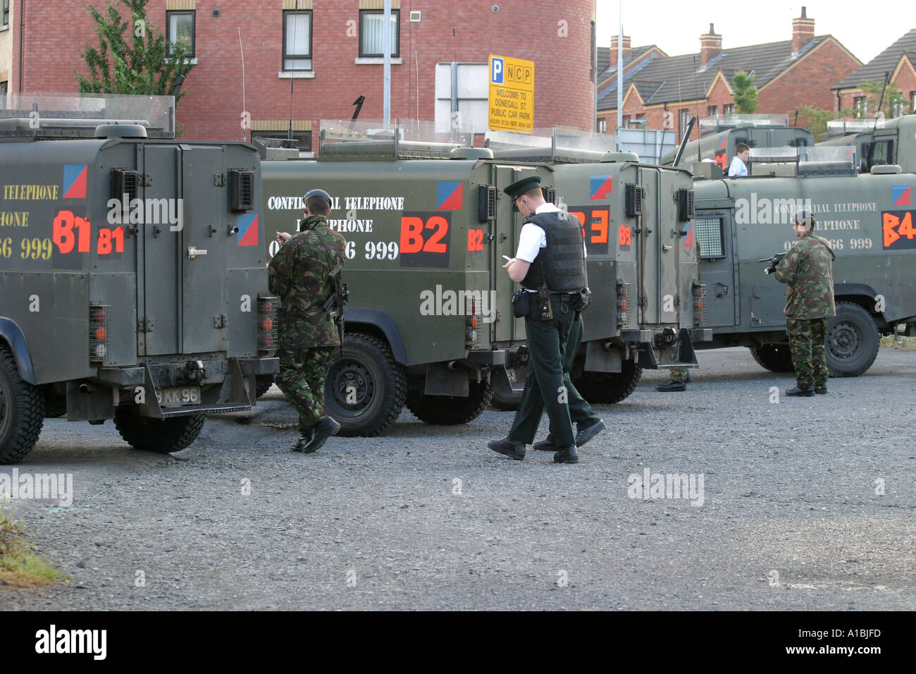Line of British Army land rovers soldiers and PSNI RUC Police officers ...