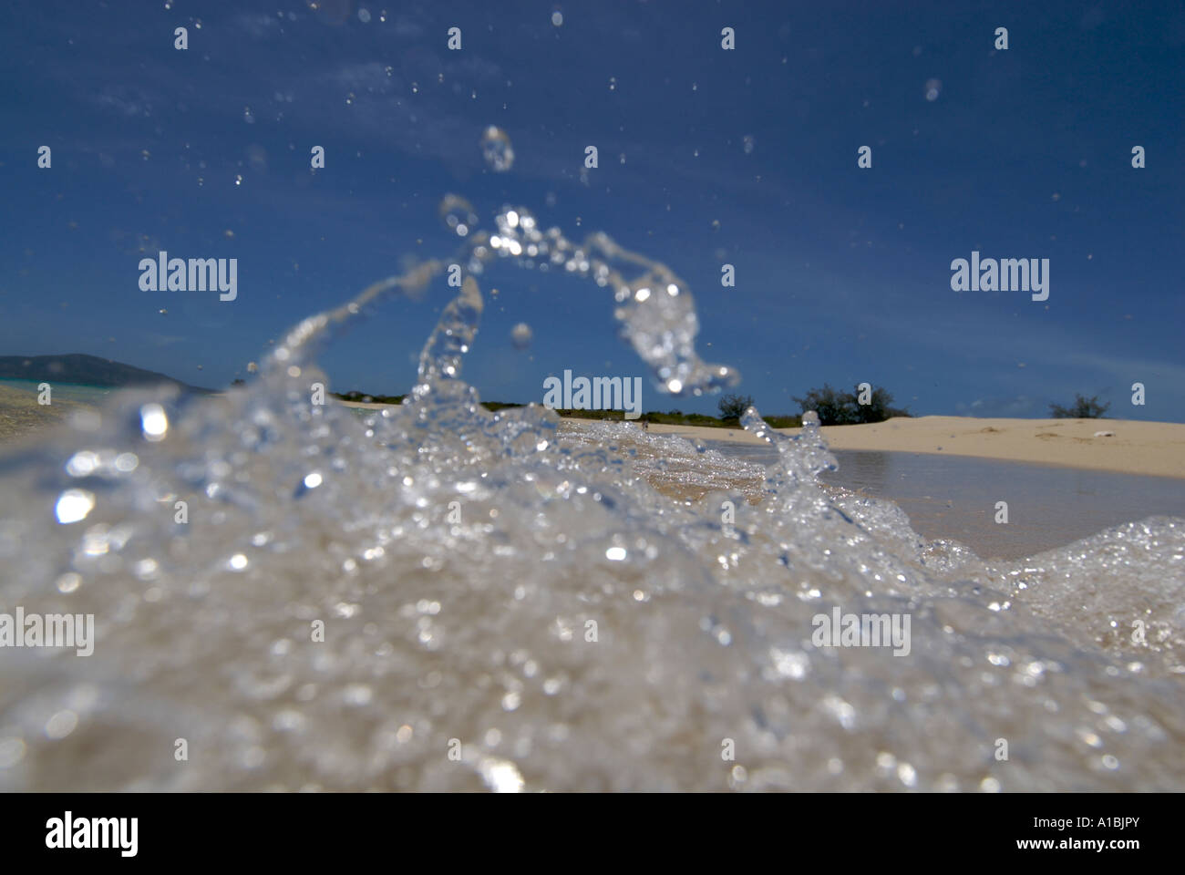 Clear tropical water splahing on a beach Stock Photo - Alamy