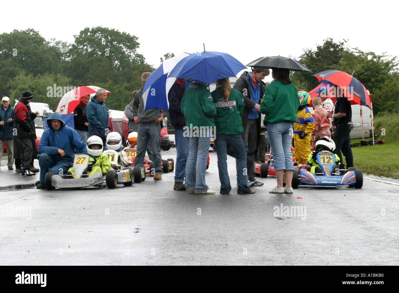 Organisers huddle under umbrellas on the grid as heavy rain stops cadet ...