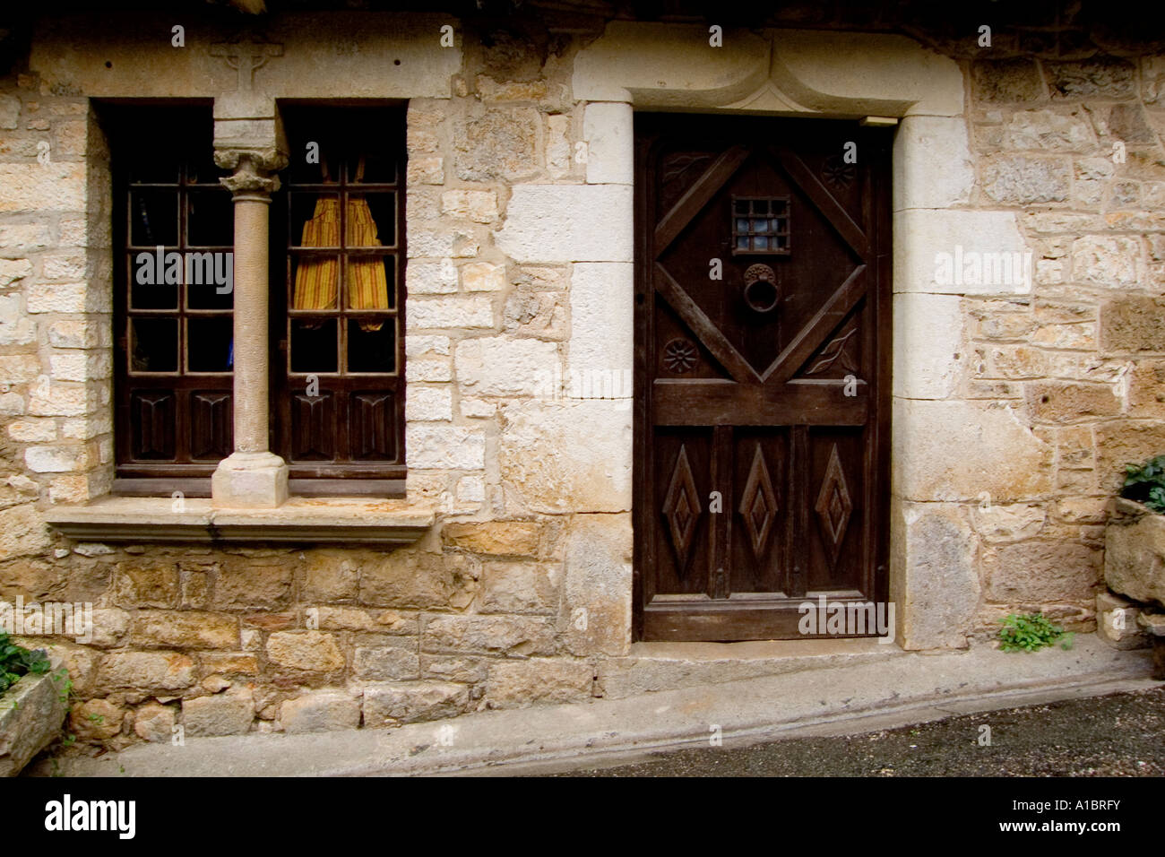 Old front door and mullioned window of a stone built cottage, St Cirq ...