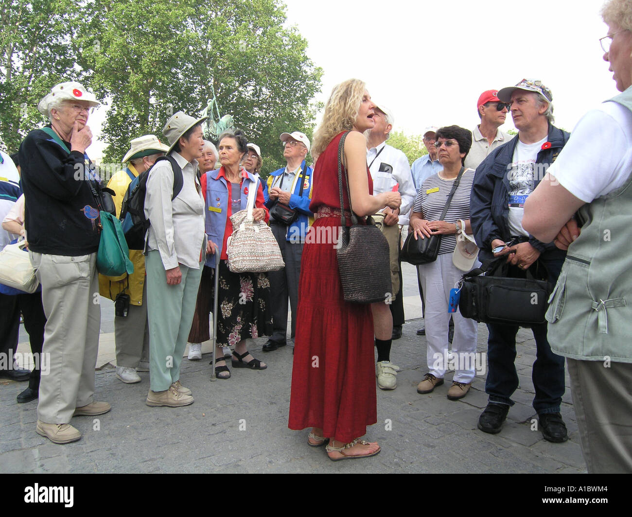 guide in red dress showing tourists around in Paris Stock Photo - Alamy