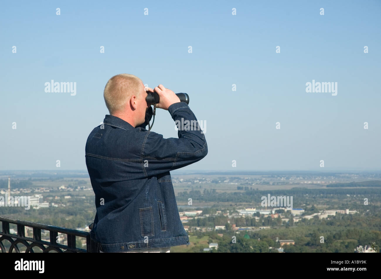 young man looking into binoculars Stock Photo - Alamy