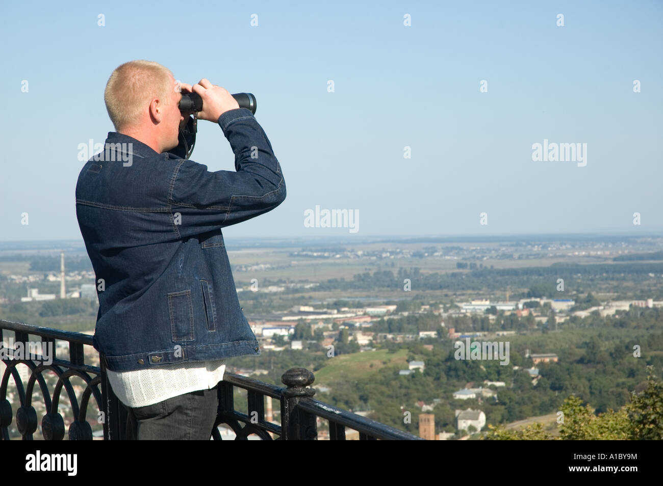 young man looking into binoculars Stock Photo - Alamy